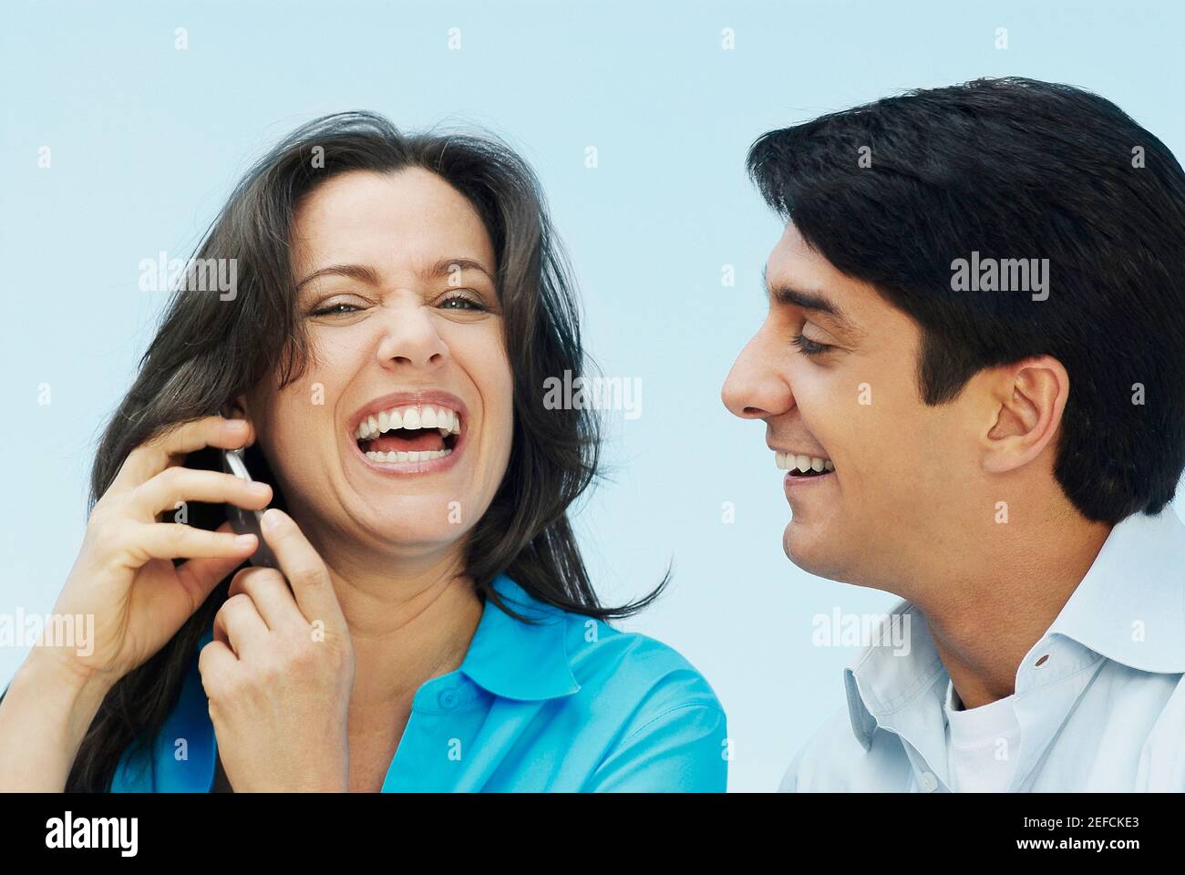 Close Up Of A Mature Woman Talking On A Mobile Phone With A Mid Adult