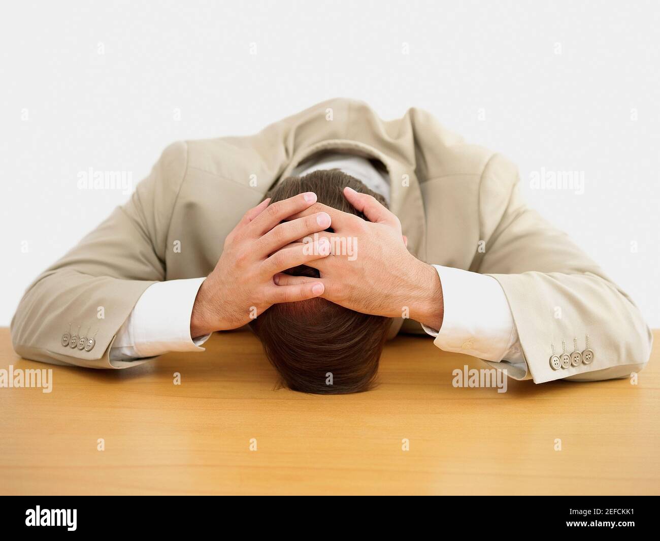Businessman leaning with his head on the table Stock Photo - Alamy