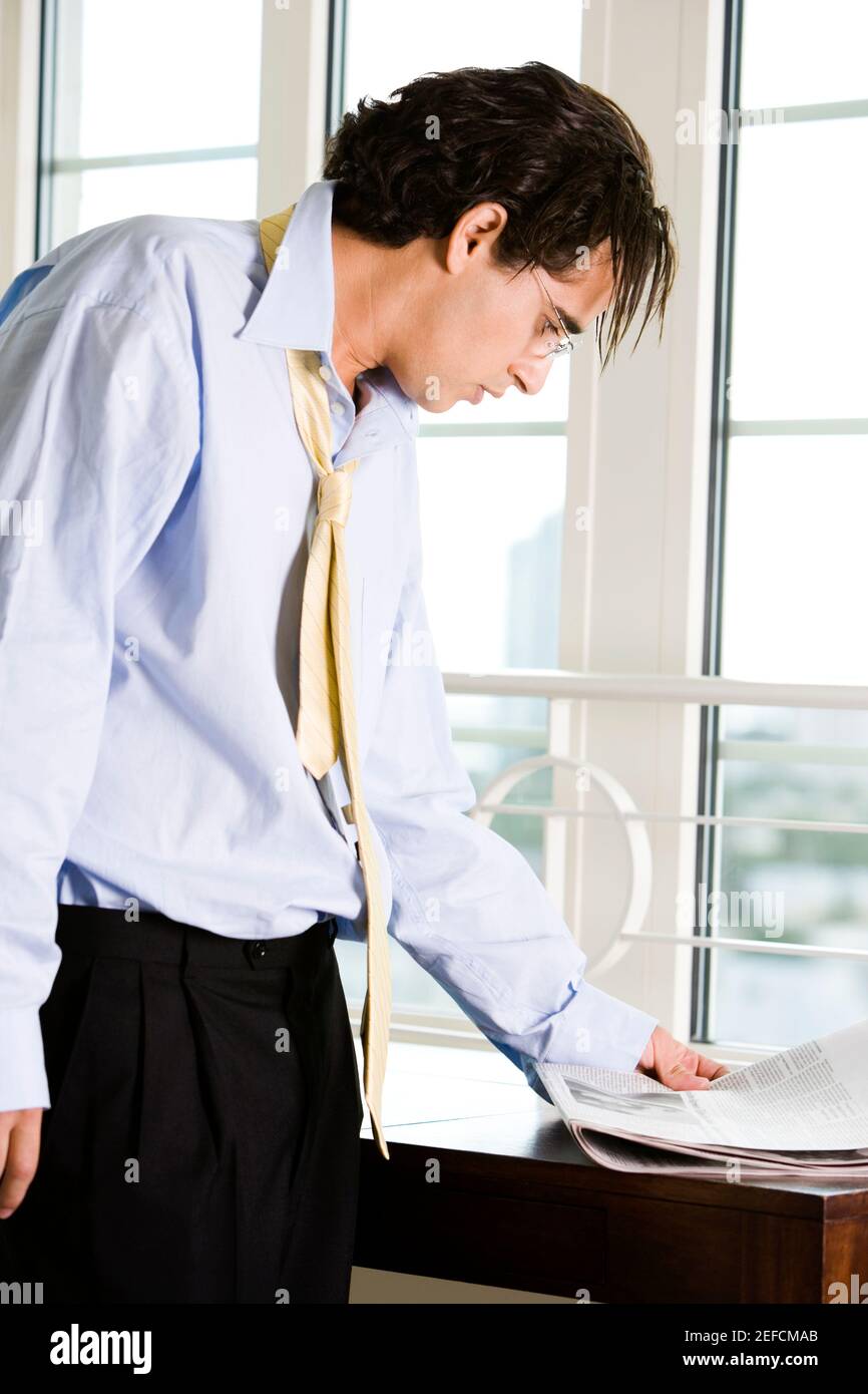 Side profile of a businessman reading a newspaper Stock Photo - Alamy