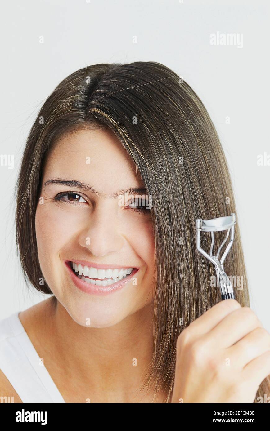 Portrait of a young woman crimping her hair Stock Photo - Alamy