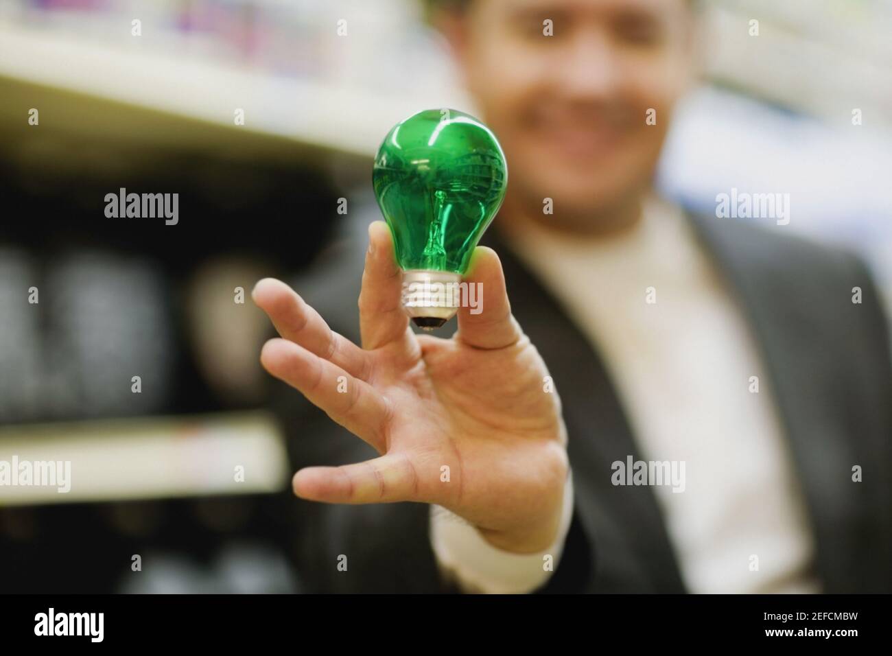 Mid adult man showing a light bulb Stock Photo - Alamy