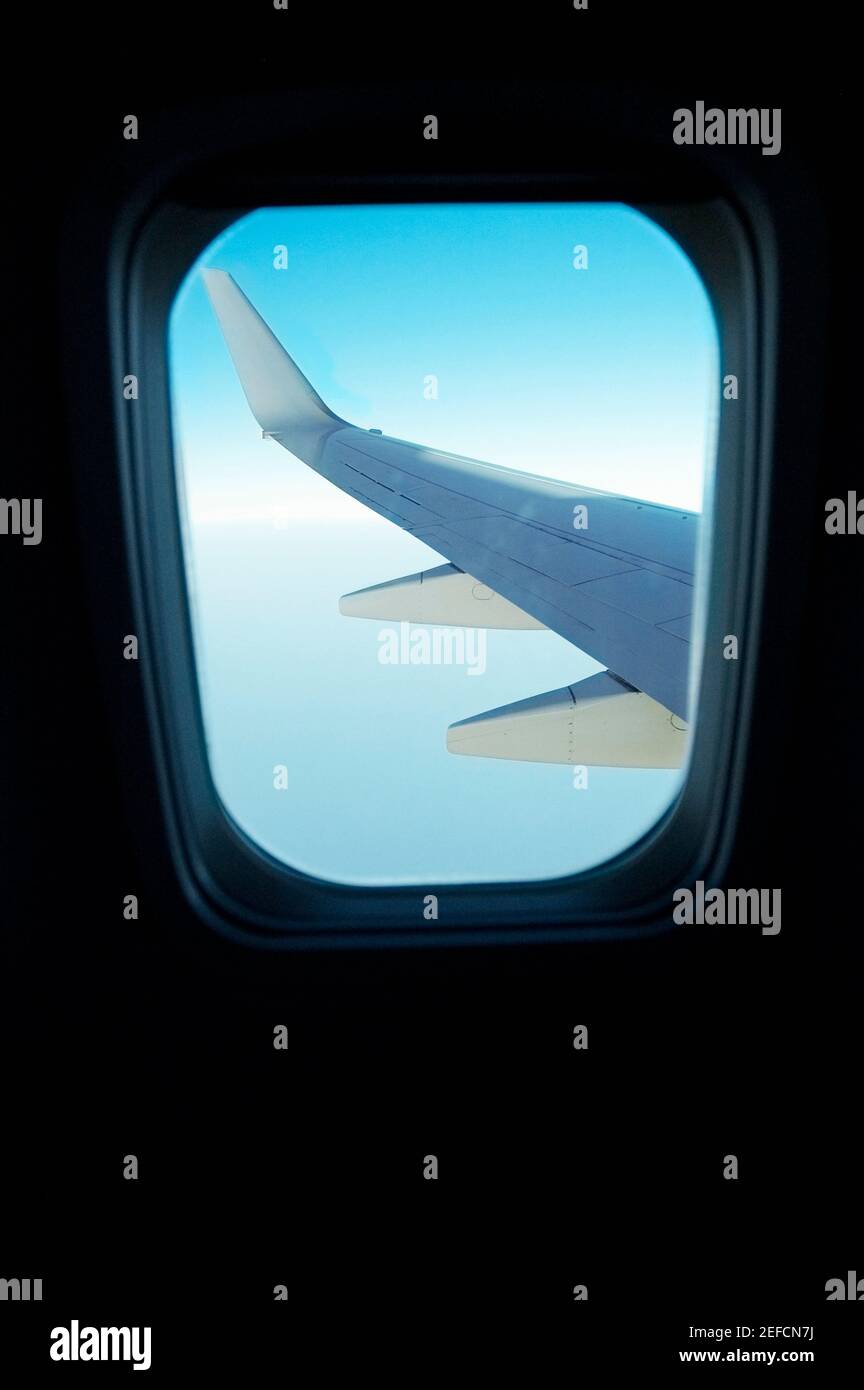 Airplane wing seen through an airplane window Stock Photo - Alamy