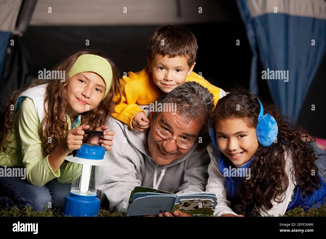 Senior man and his three grandchildren smiling Stock Photo - Alamy