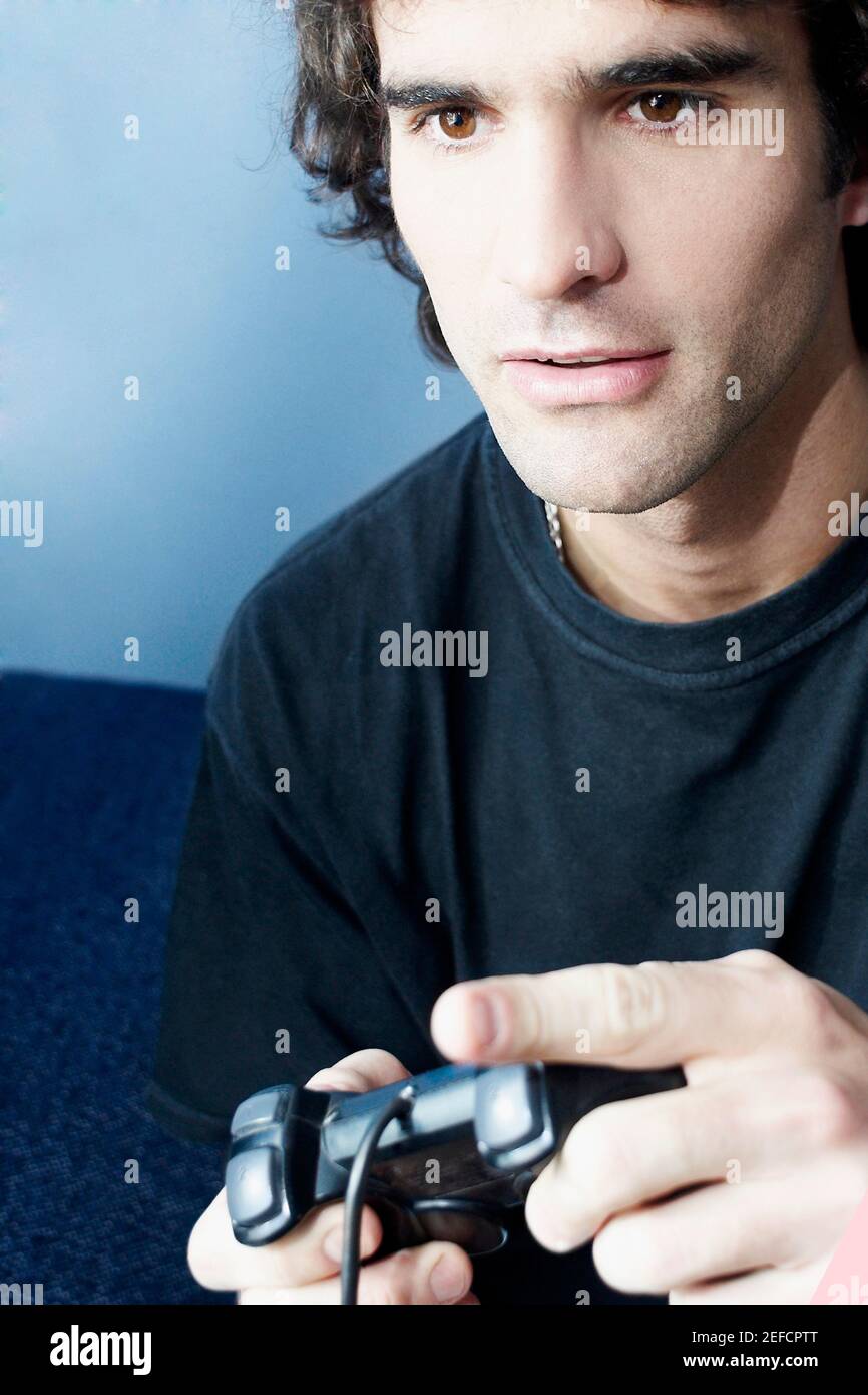 Close up of a young man playing a video game Stock Photo - Alamy