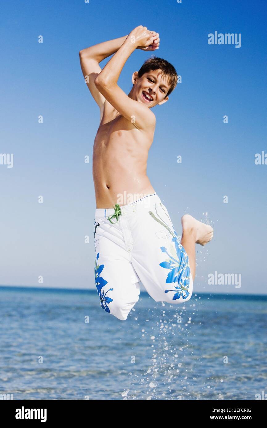Teenage boy jumping on the beach Stock Photo - Alamy