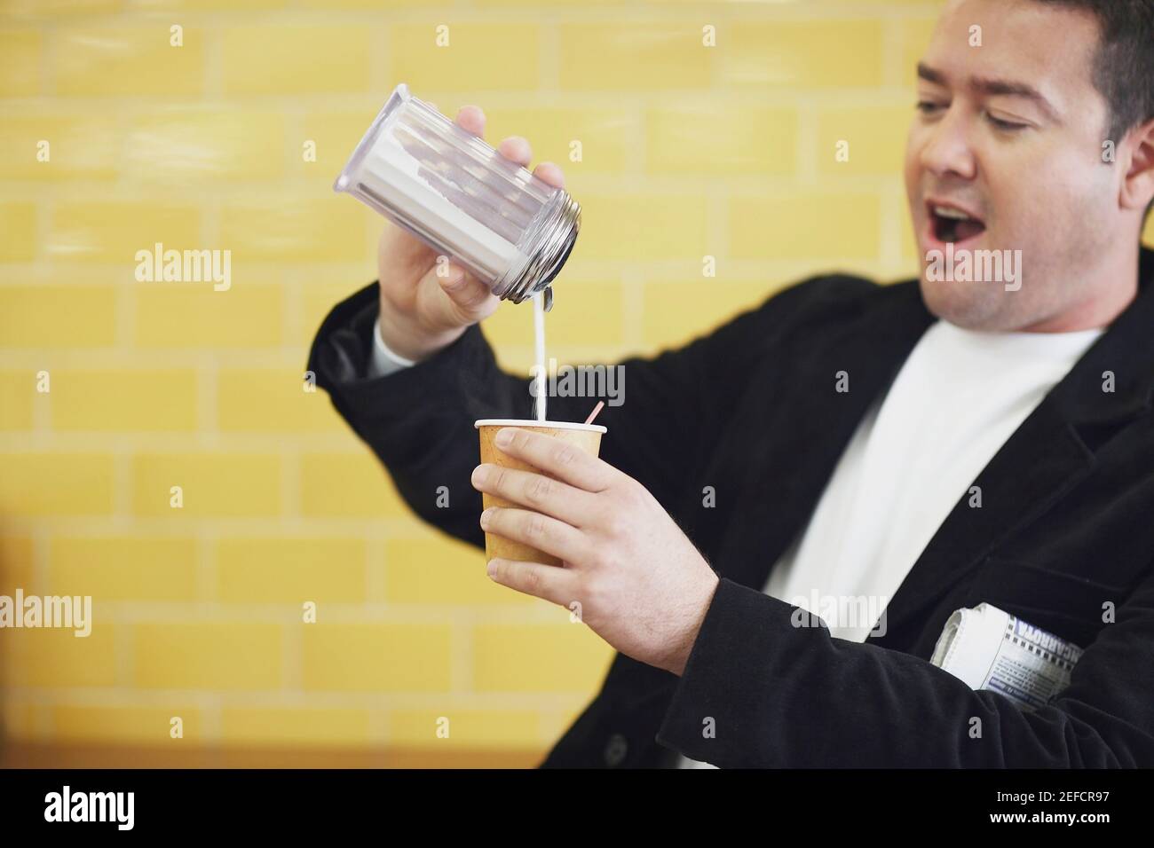 Mid adult man pouring milk into a disposable cup Stock Photo - Alamy