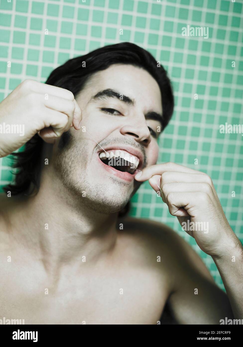 Portrait of a young man flossing his teeth Stock Photo - Alamy