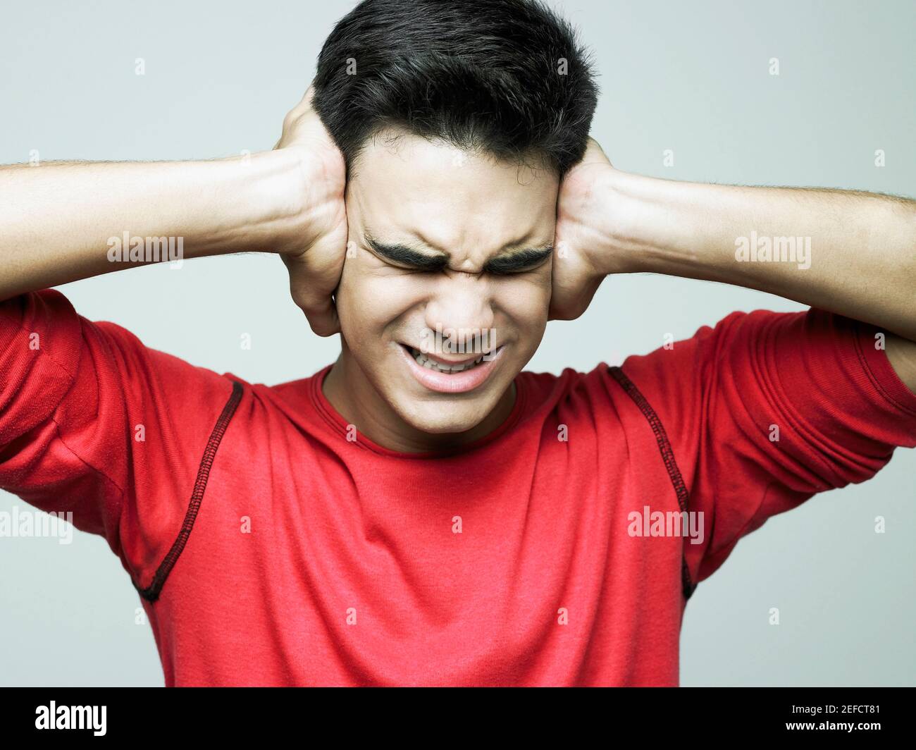 Young man covering his ears Stock Photo - Alamy