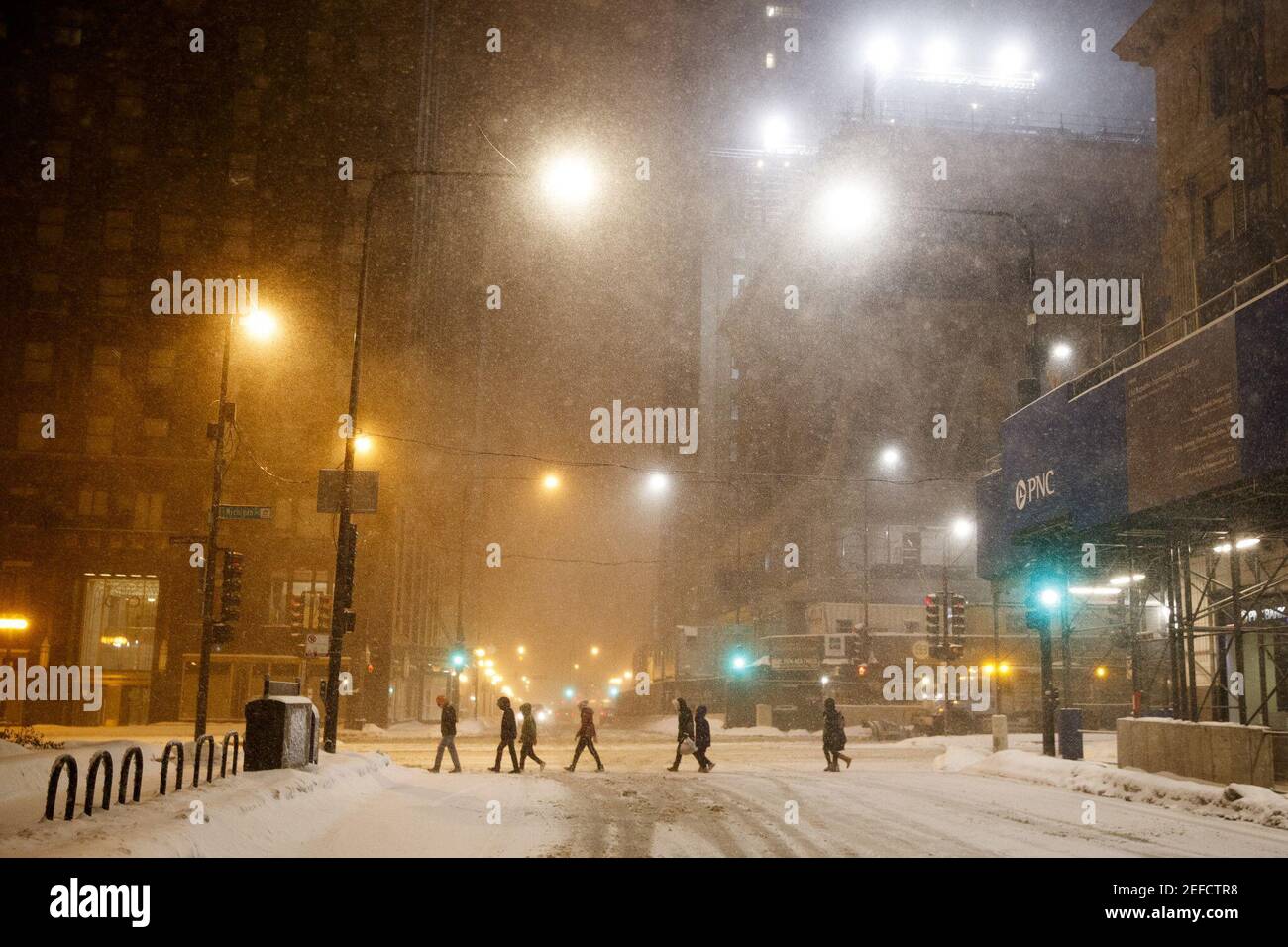 People trudge through snow along North Michigan Avenue on Feb. 15, 2021 ...