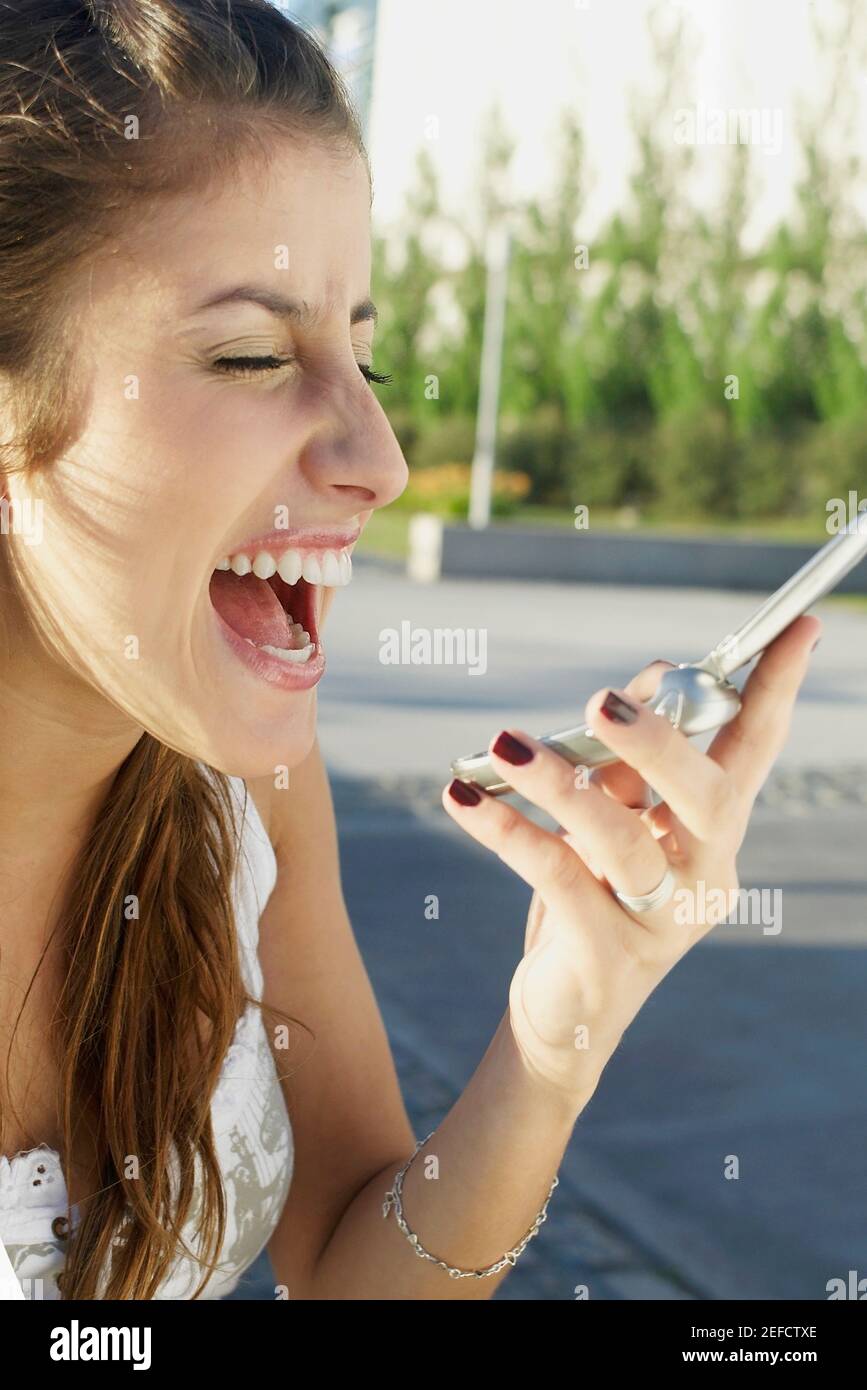 Close up of a young woman shouting on a mobile phone Stock Photo - Alamy