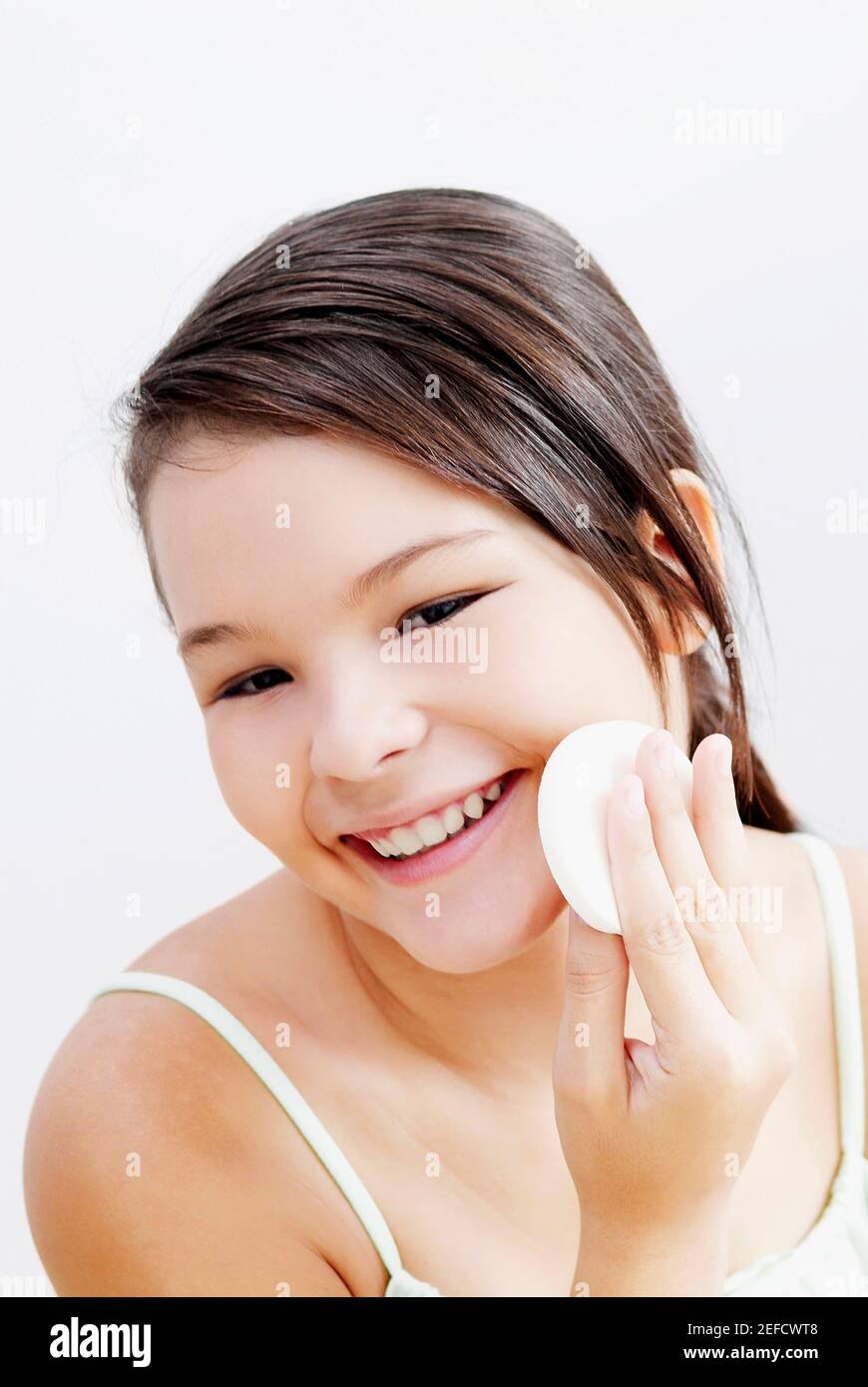 Portrait of a teenage girl applying face powder on her cheeks Stock ...