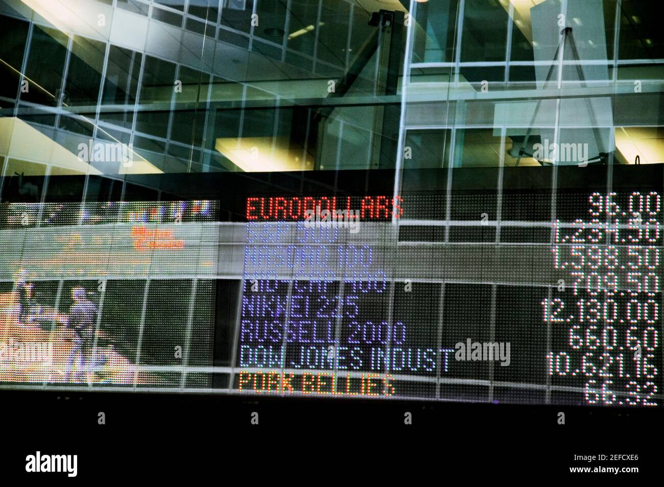 Screen showing currency and market rates through a window of a building ...