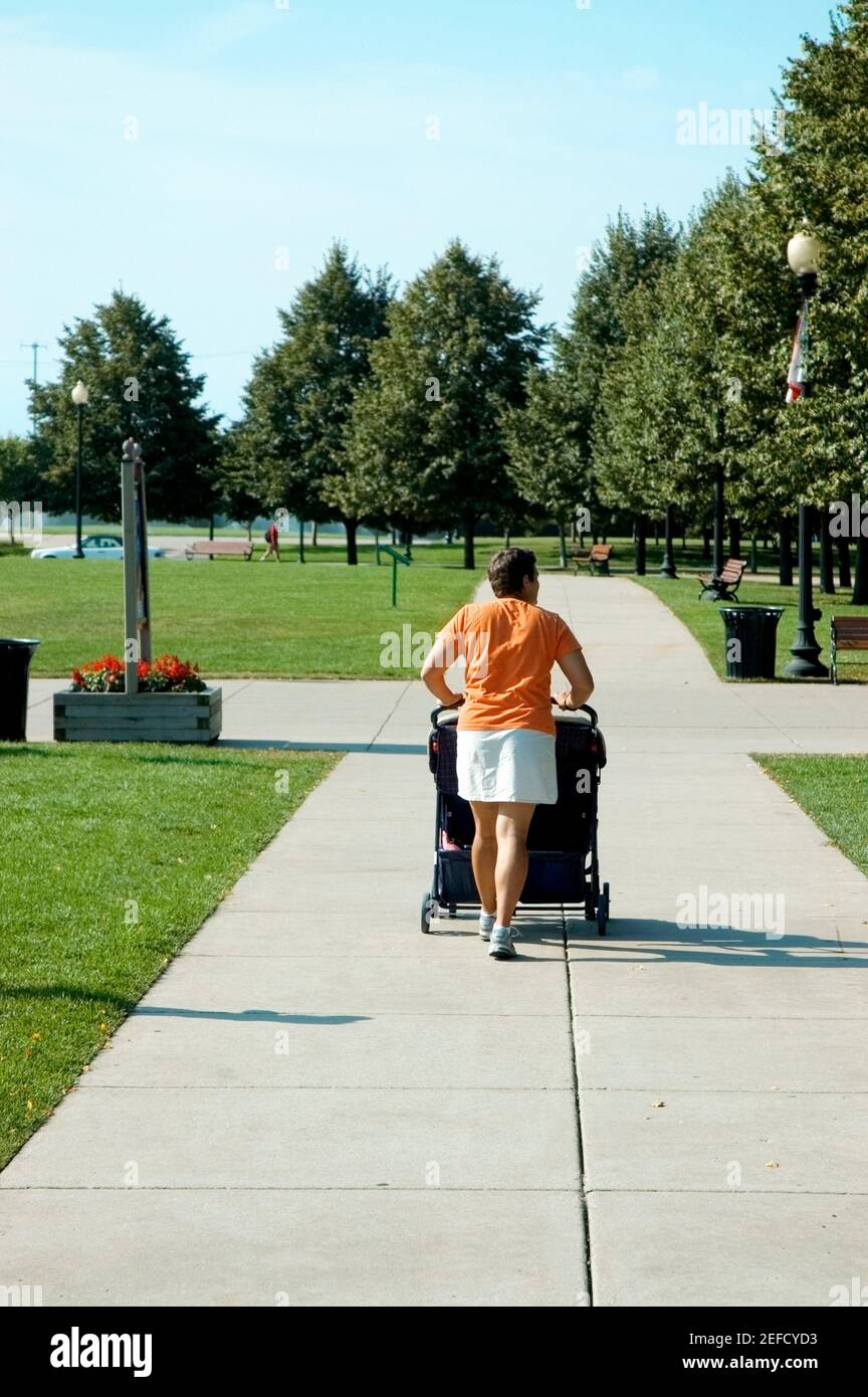 Rear view of a woman pushing a baby stroller, Gateway Park, Chicago ...