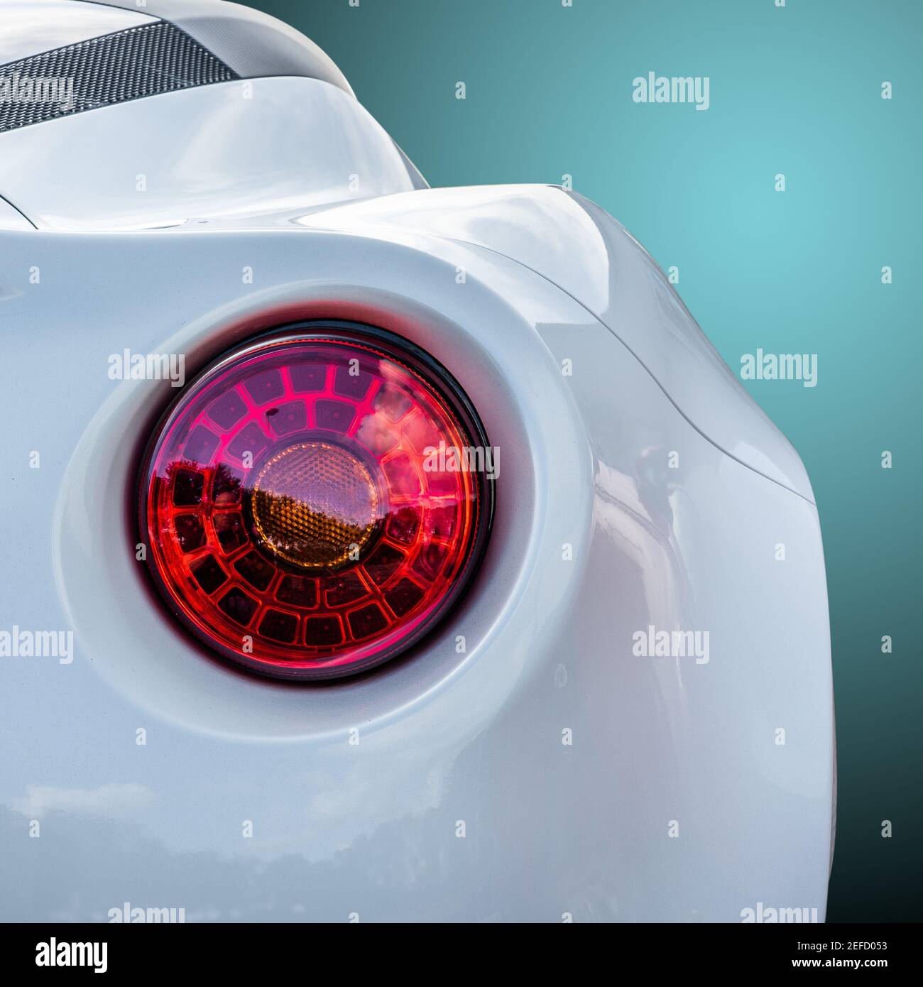 Round rear light of a sports car on a blue background Stock Photo - Alamy