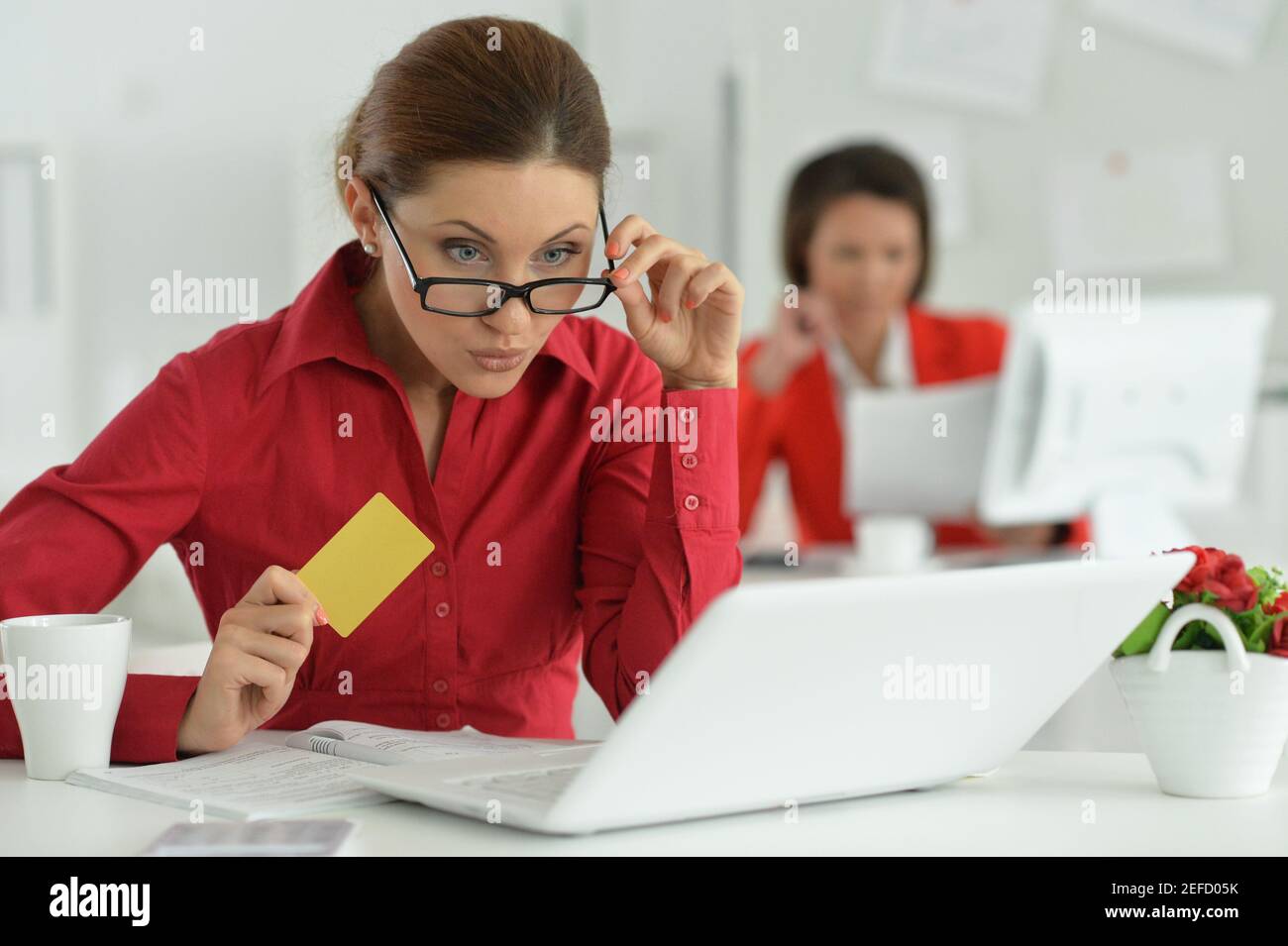 Businesswoman with credit card working in modern office with her ...