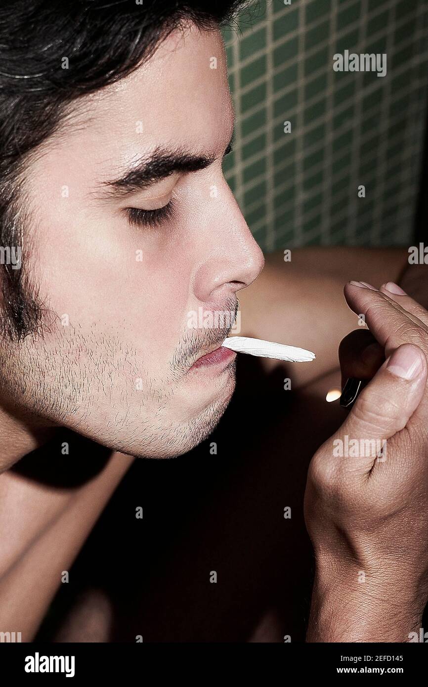 Portrait of young man lighting cigarette hi-res stock photography and ...