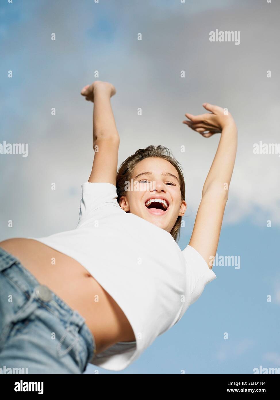 Low angle view of a teenage girl with her arms raised Stock Photo - Alamy
