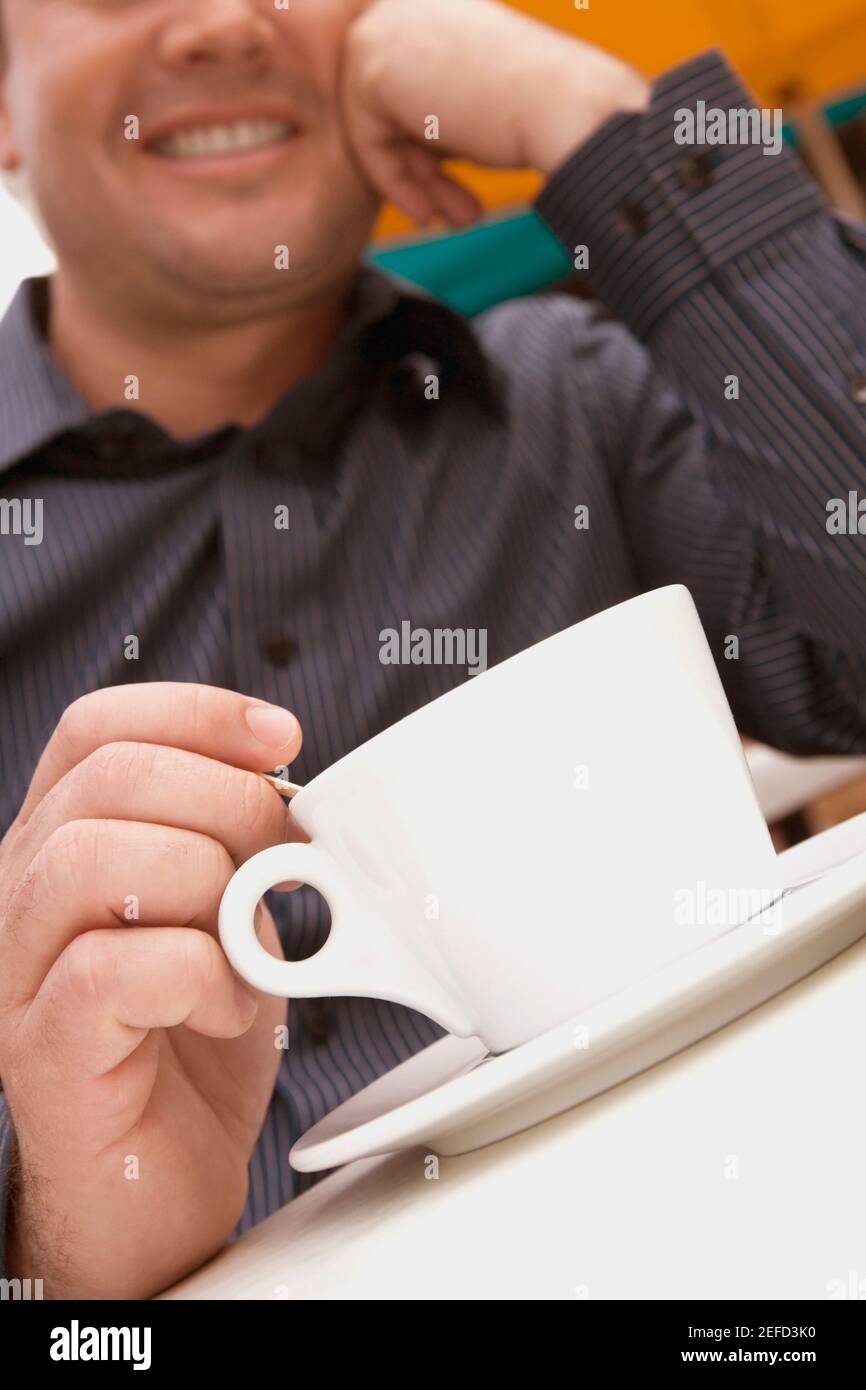 Mid adult man stirring tea Stock Photo - Alamy