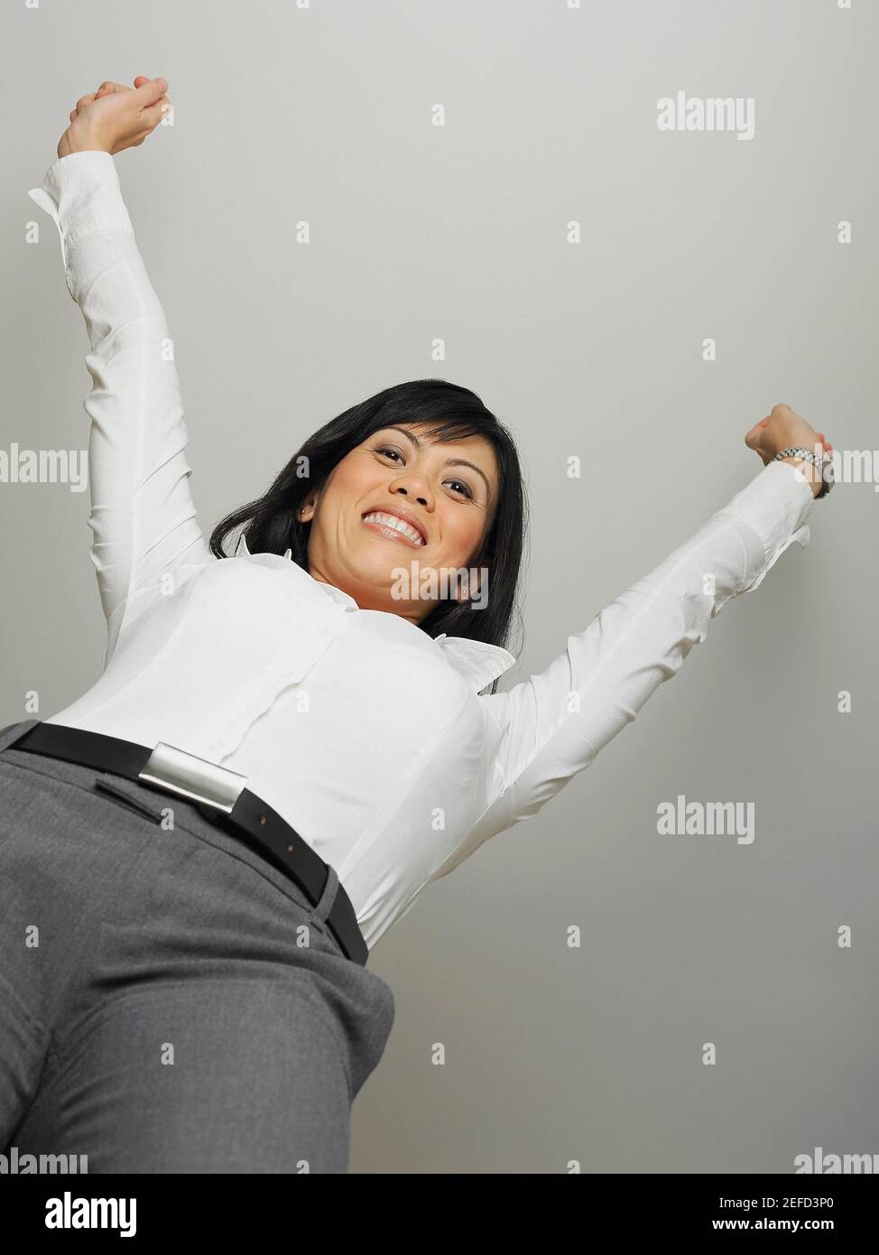 Low angle view of a mid adult woman standing with her arms raised Stock ...