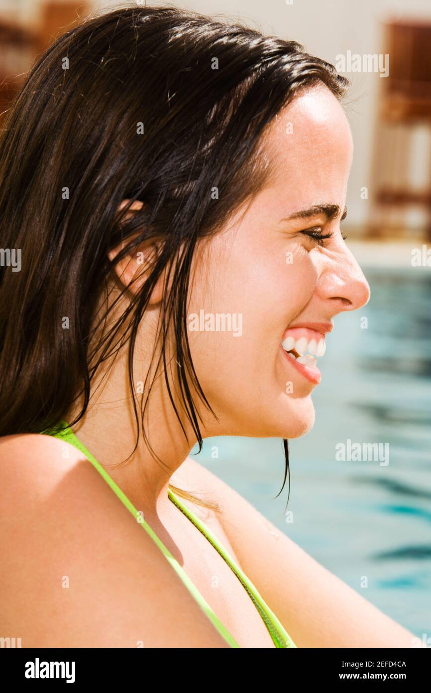 Side profile of a young woman smiling in a swimming pool Stock Photo ...