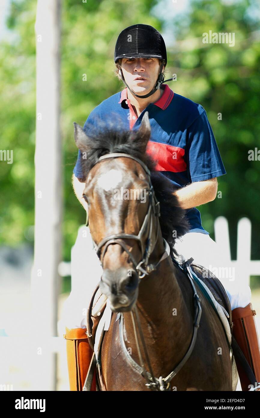 Portrait of a mid adult man horseback riding Stock Photo - Alamy