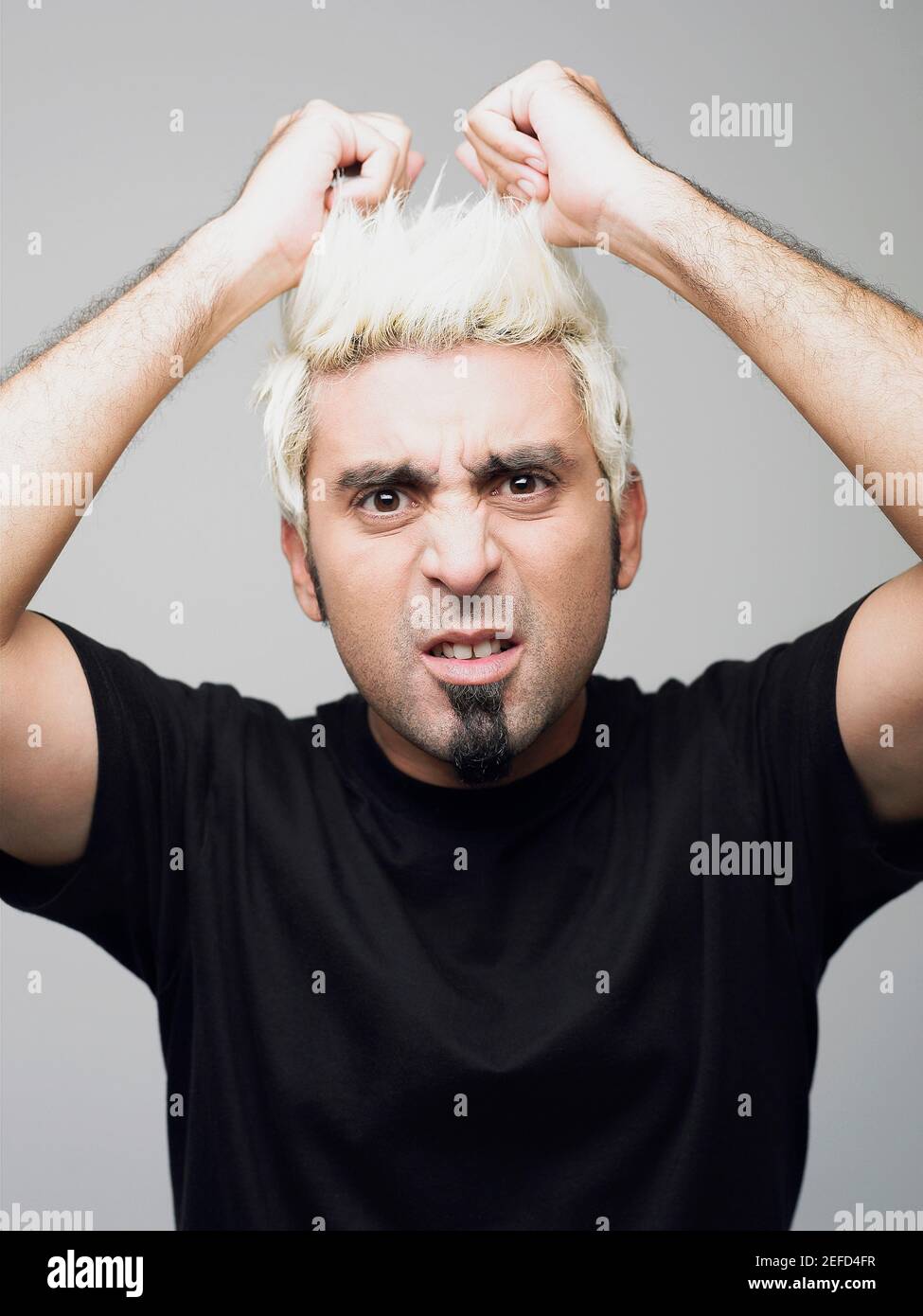 Portrait of a young man looking angry Stock Photo - Alamy