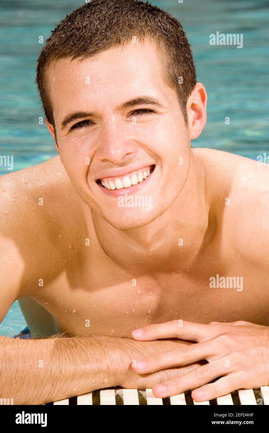 Portrait of a young man smiling in a swimming pool Stock Photo - Alamy