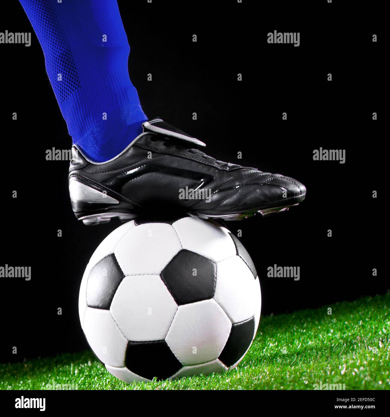 soccer ball and feet on the football field, football player in blue ...