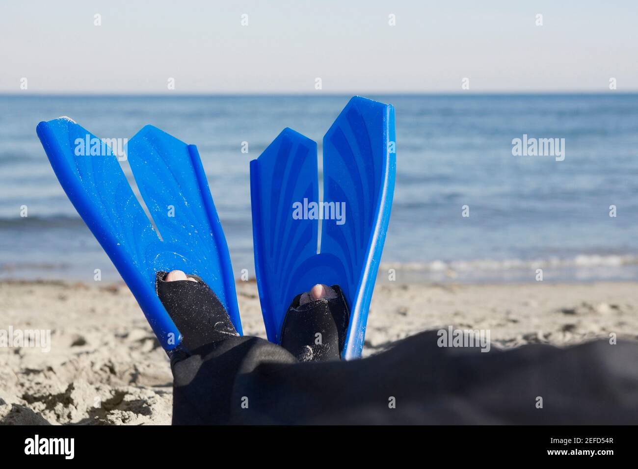 Close up of a personŽs legs with flippers on the beach Stock Photo - Alamy