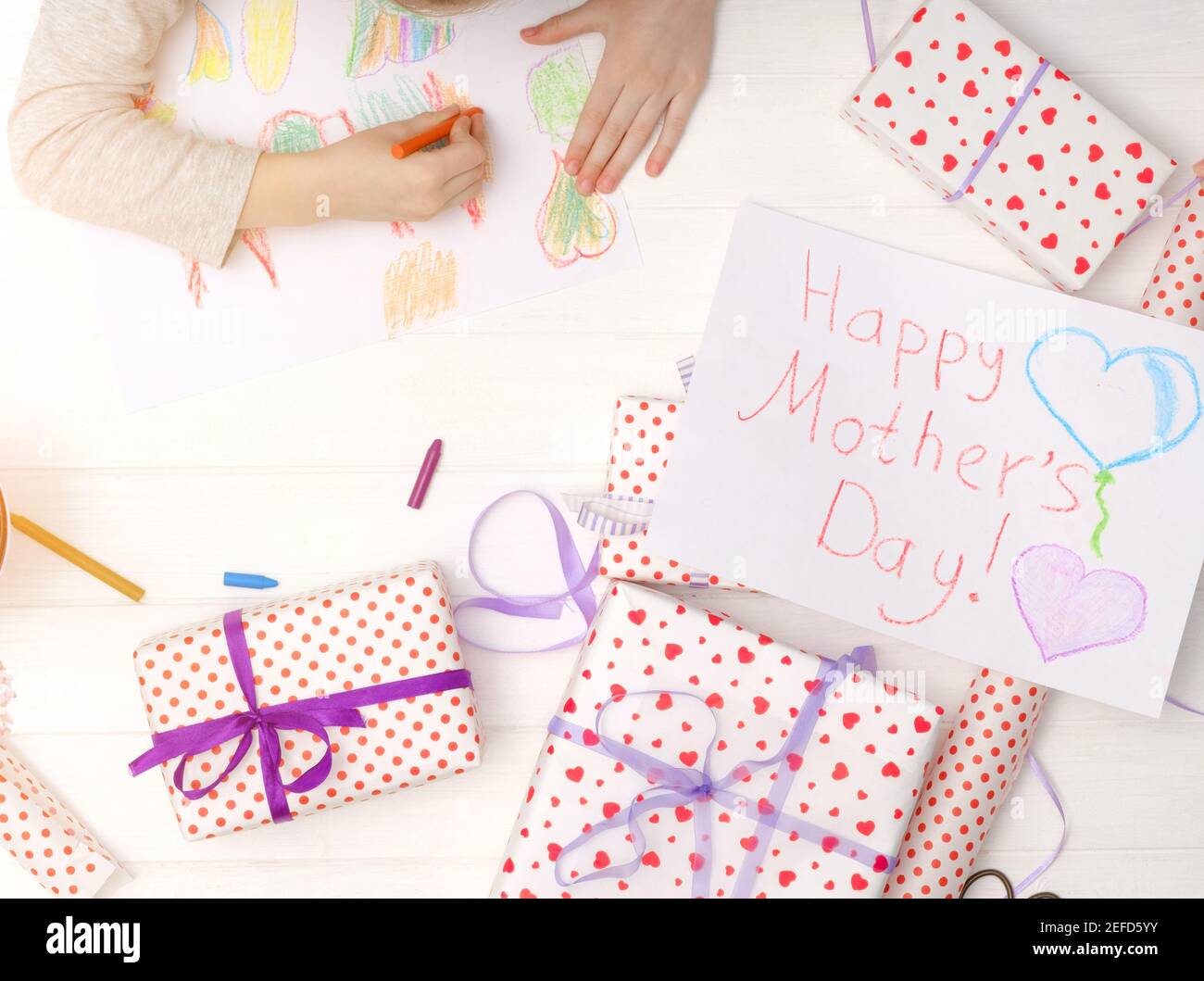 Little girl drawing happy mother's day greeting card with presents on ...