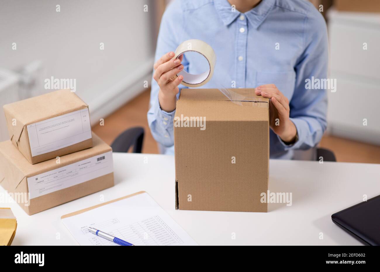 woman packing parcel box with adhesive tape Stock Photo - Alamy