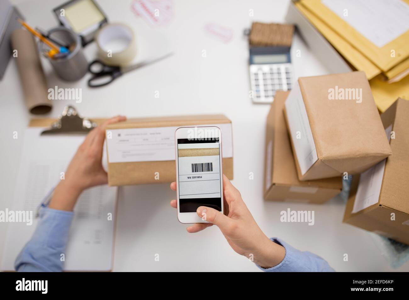 hands with smartphone scans barcode on parcel box Stock Photo - Alamy