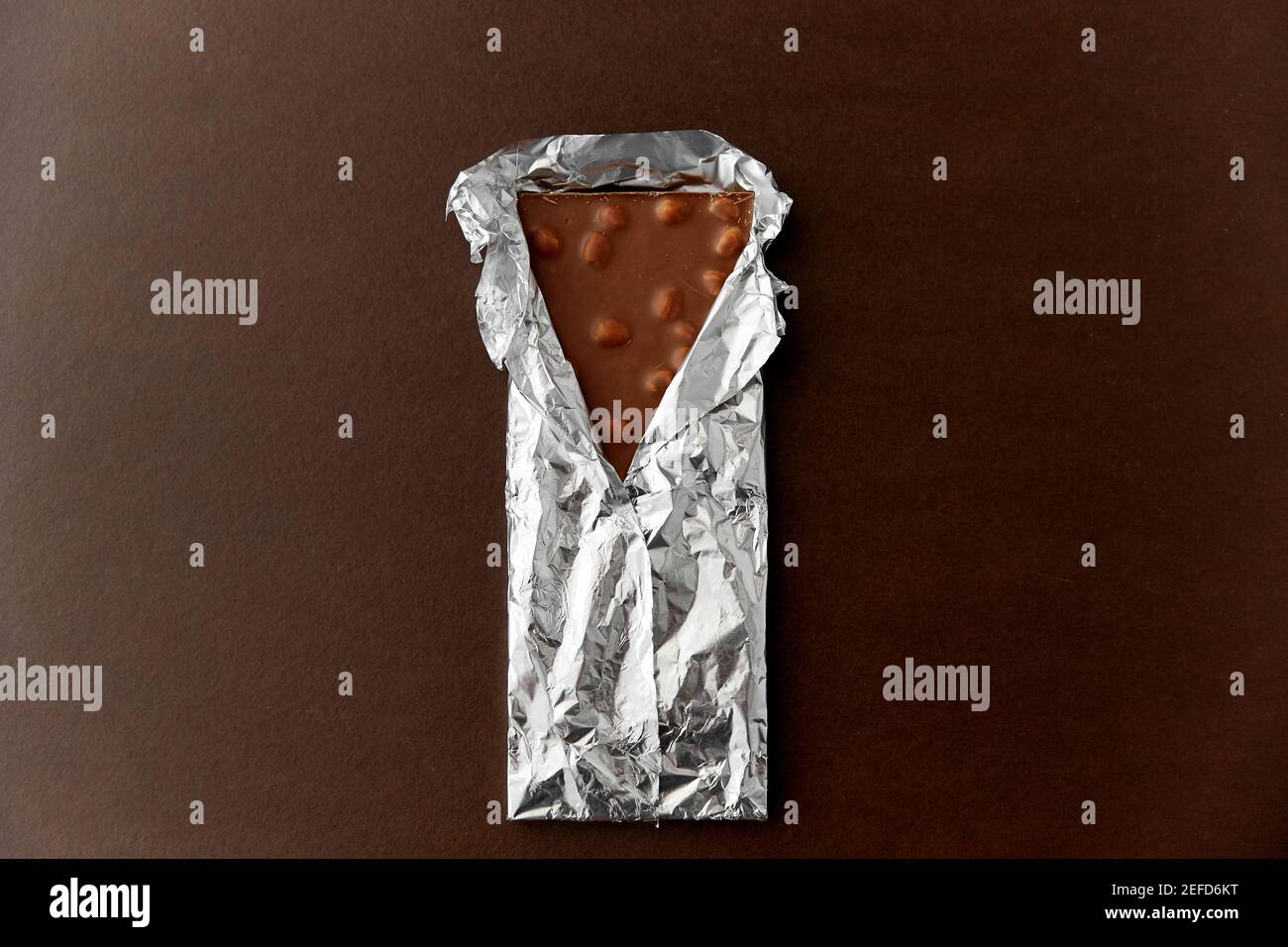 milk chocolate bar with nuts in foil wrapper Stock Photo - Alamy