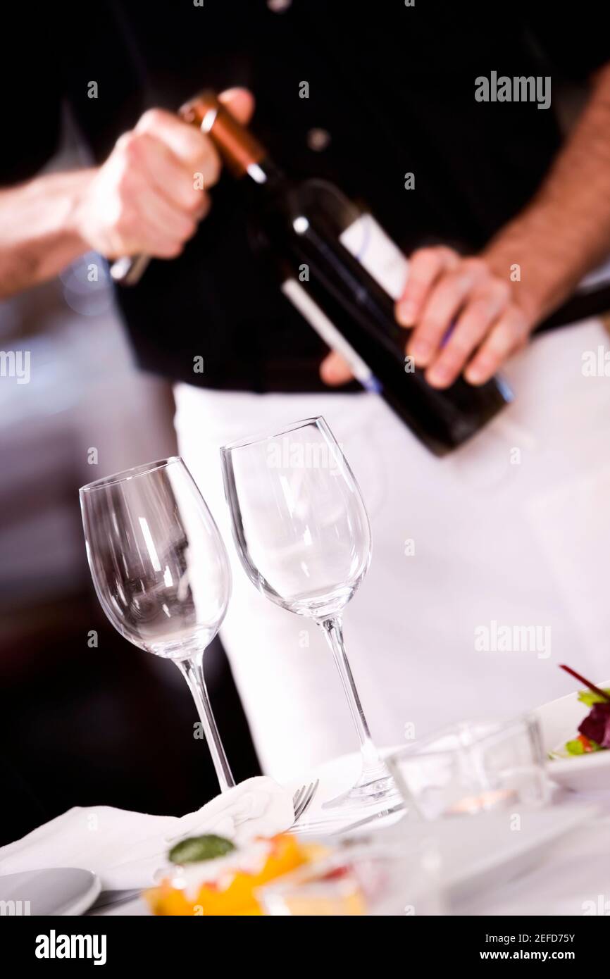 Mid section view of a man opening the cork of a wine bottle Stock Photo ...