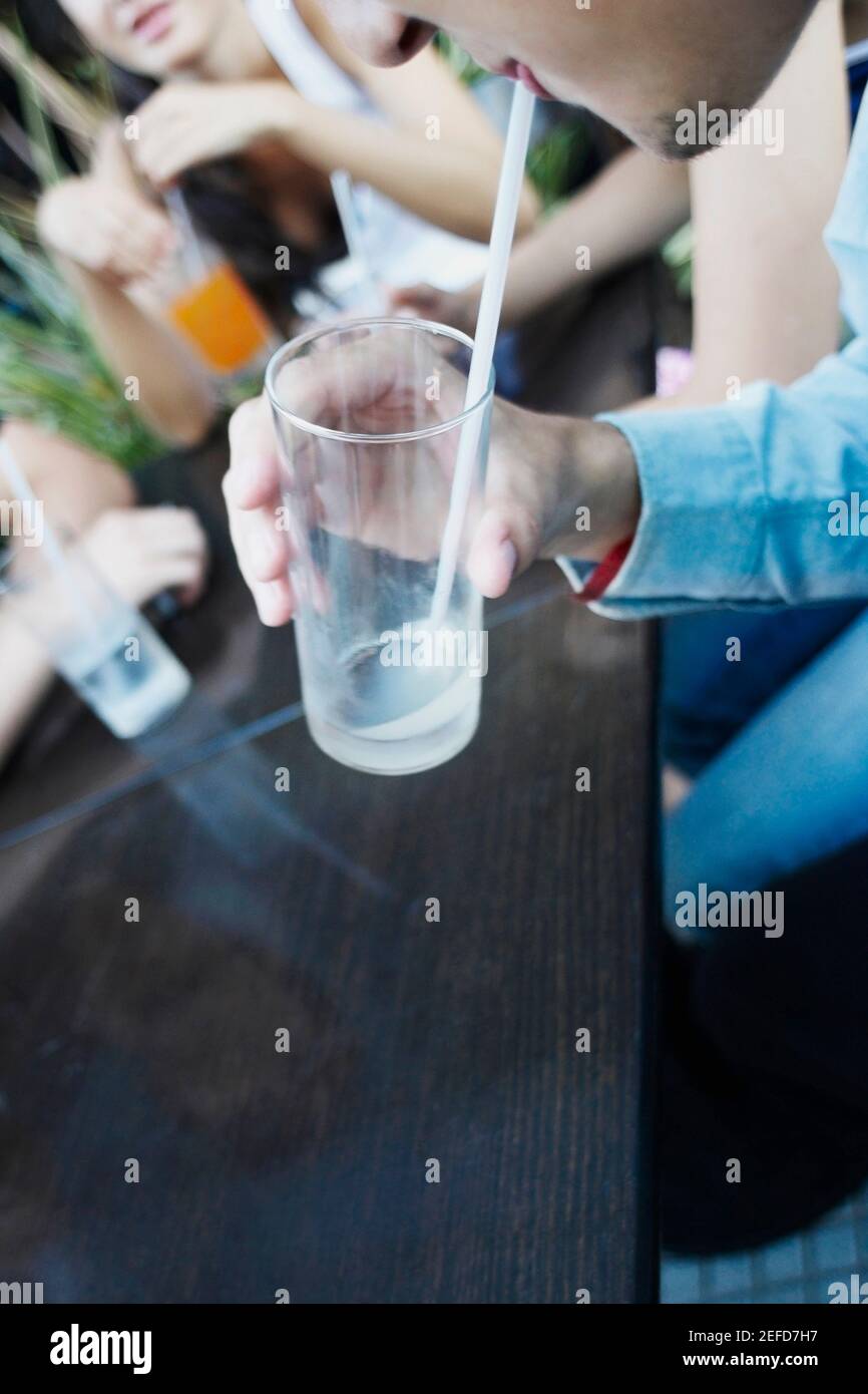 Close up of a man drinking a glass of soda with a drinking straw Stock ...