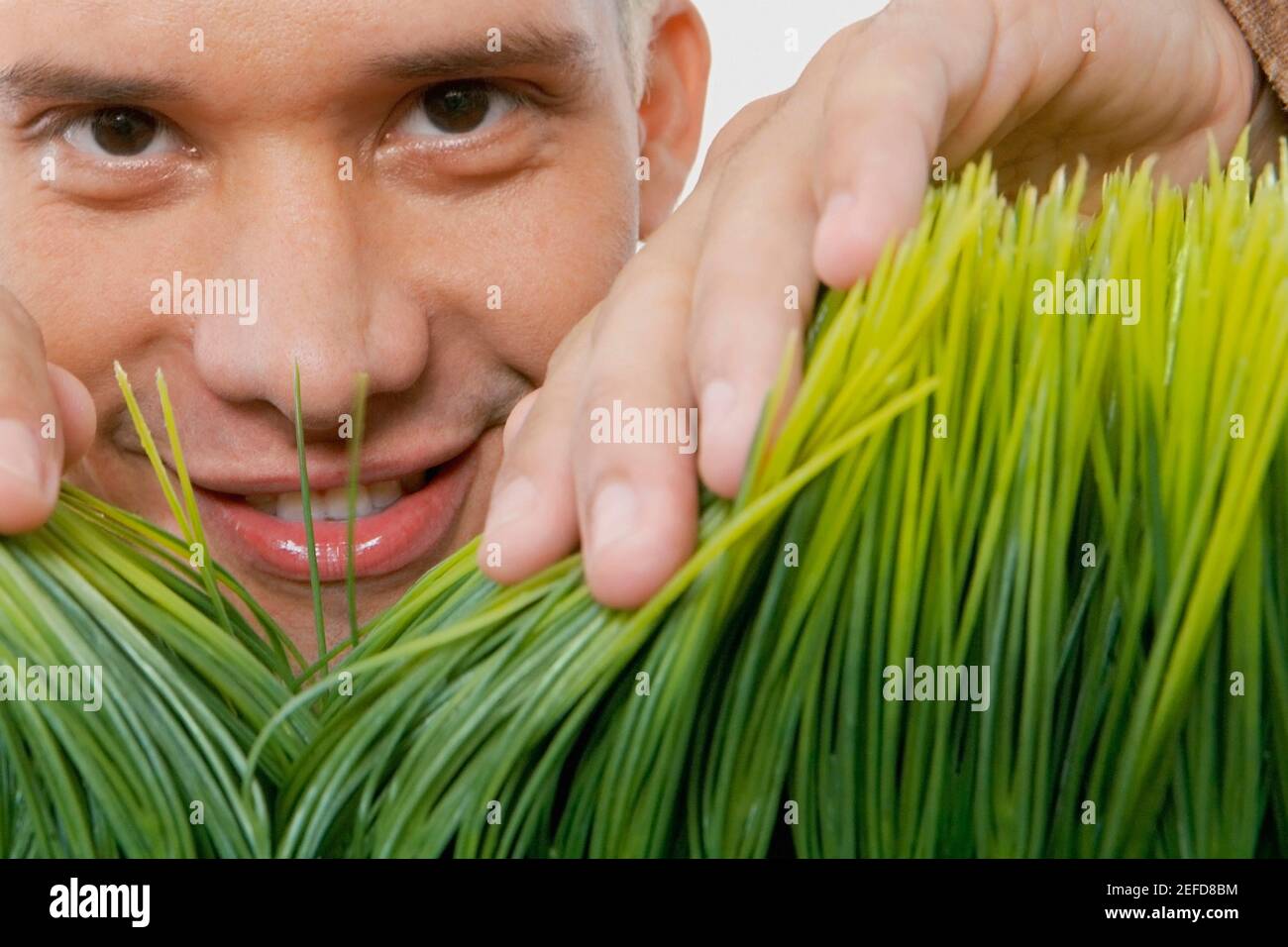 Portrait of a young man parting grass saplings with his hands Stock ...