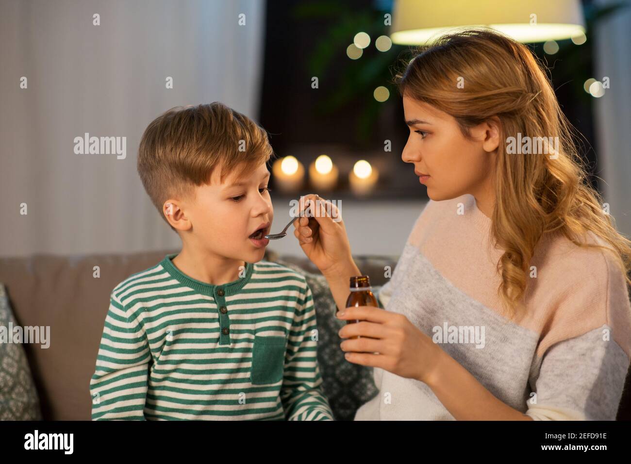 mother giving medication or cough syrup to ill son Stock Photo - Alamy
