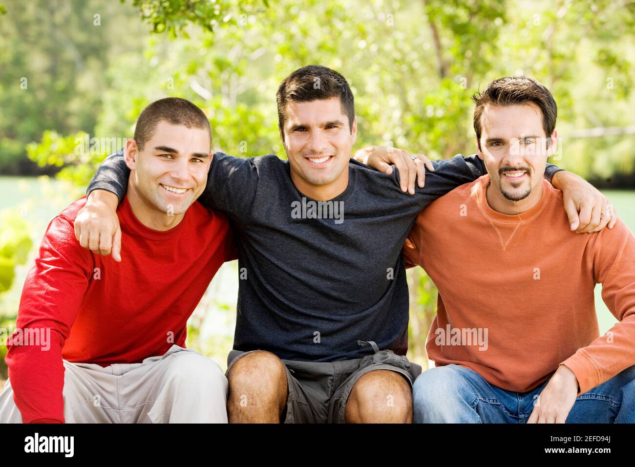 Portrait of three friends sitting and smiling Stock Photo - Alamy