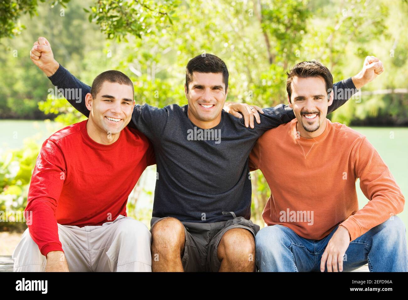 Portrait of three friends sitting and smiling Stock Photo - Alamy
