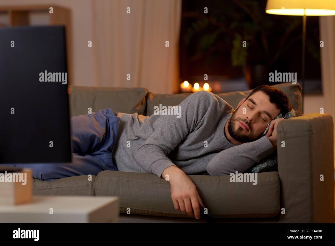 man sleeping on sofa with tv remote at home Stock Photo - Alamy