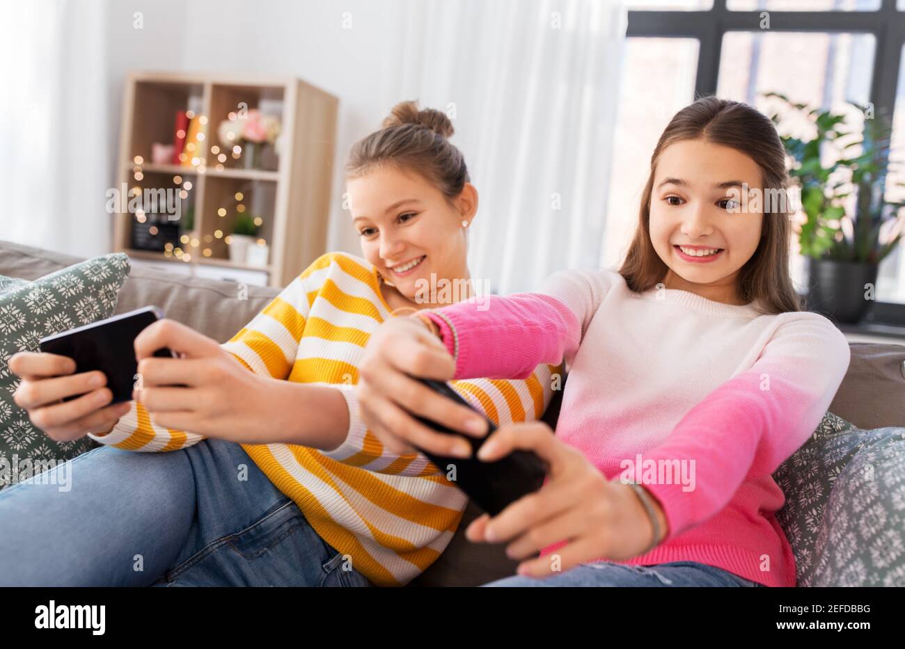 girls and playing game on smartphones at home Stock Photo - Alamy