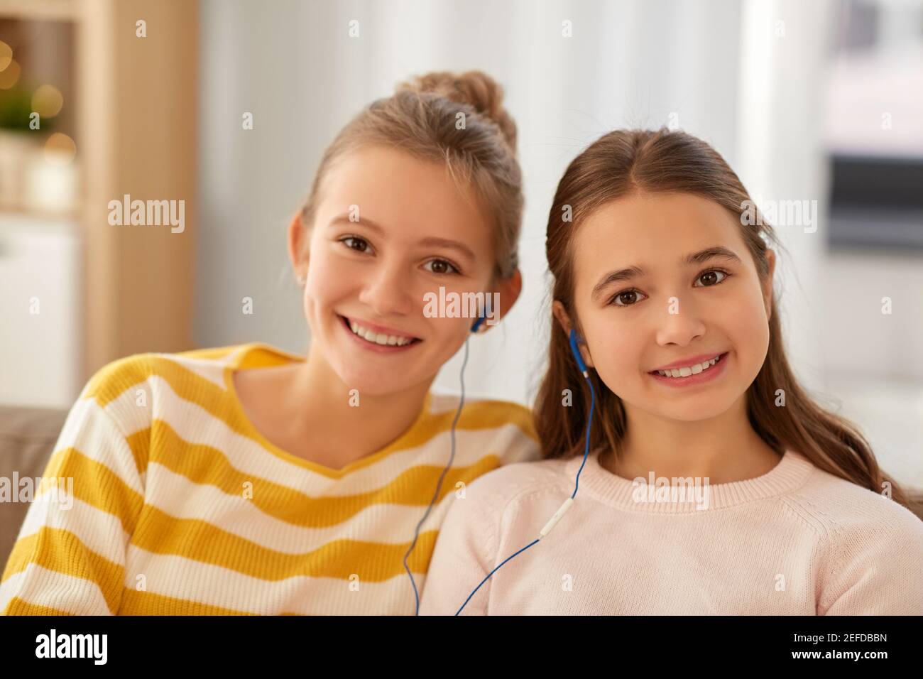happy girls with earphones listen to music at home Stock Photo - Alamy