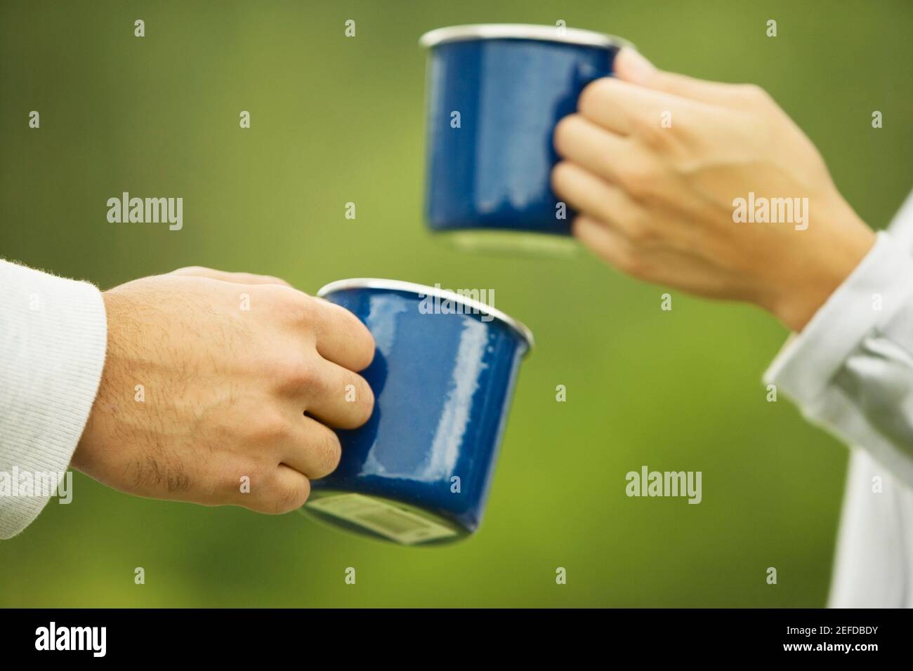 Two hands holding cups hi-res stock photography and images - Alamy