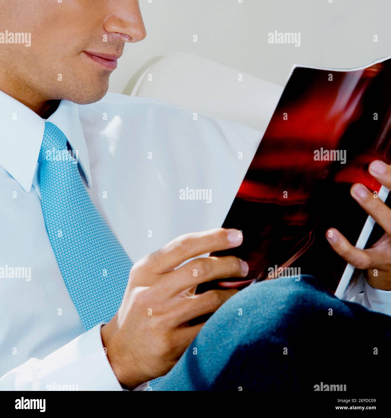 Mid section view of a businessman reading a magazine Stock Photo - Alamy