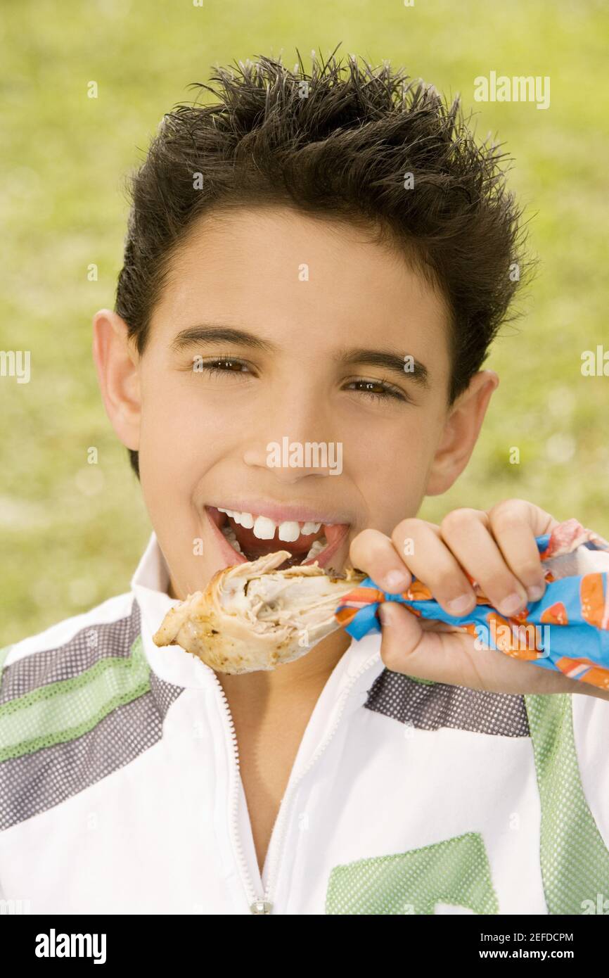 Portrait of a boy eating a chicken drumstick Stock Photo - Alamy