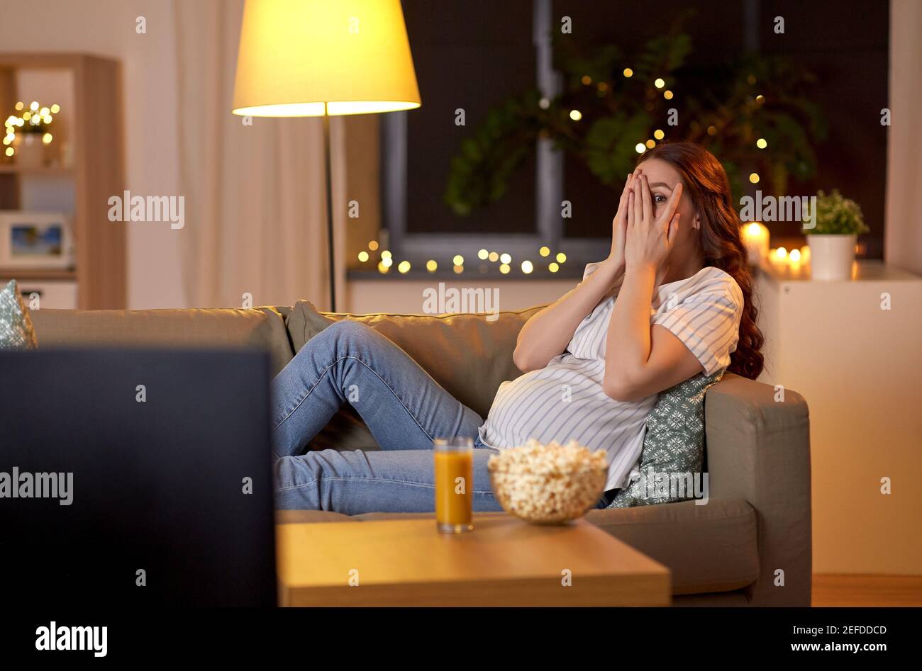 scared pregnant woman watching tv at home Stock Photo - Alamy