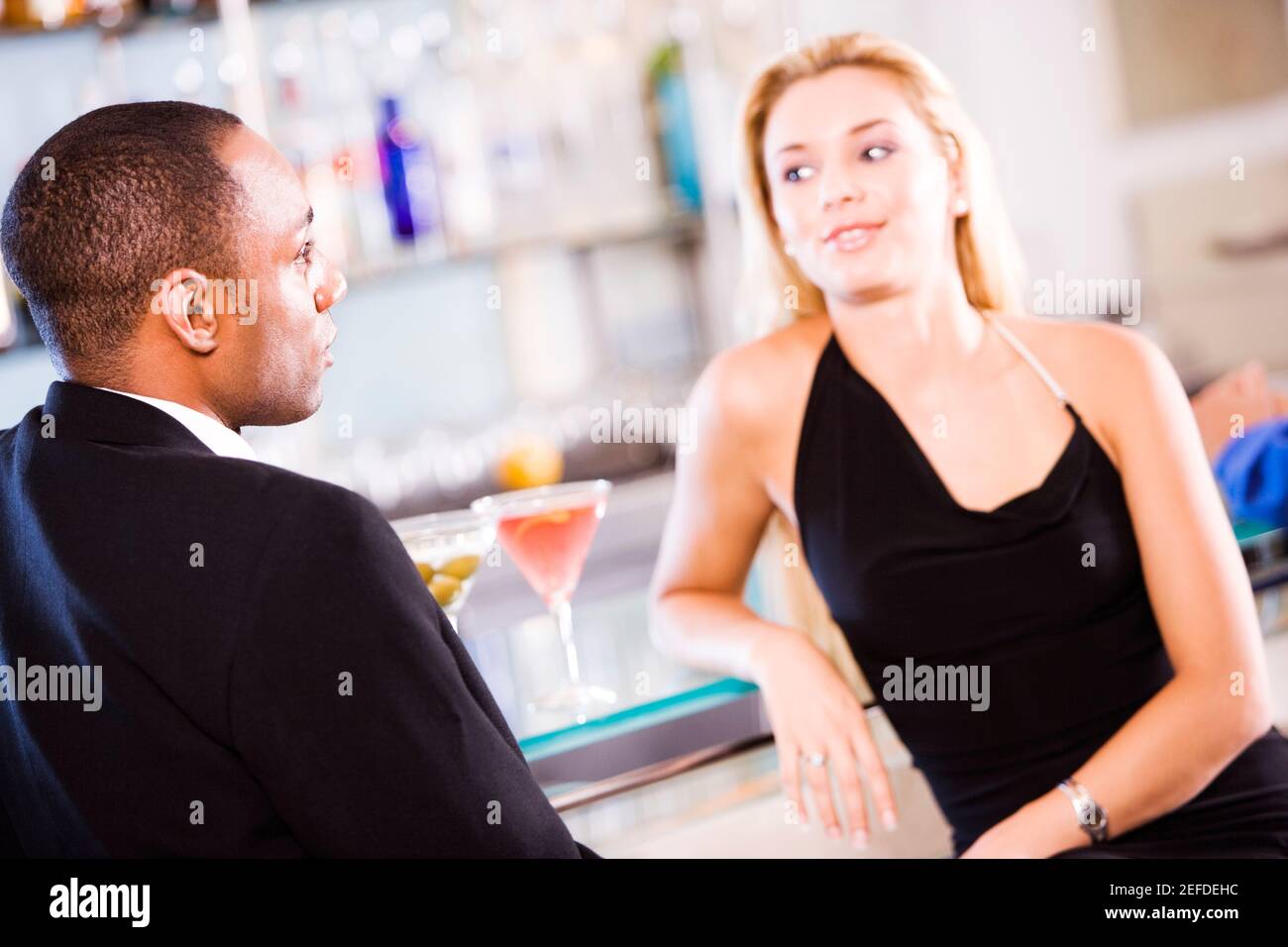 Young couple sitting at a bar counter Stock Photo - Alamy