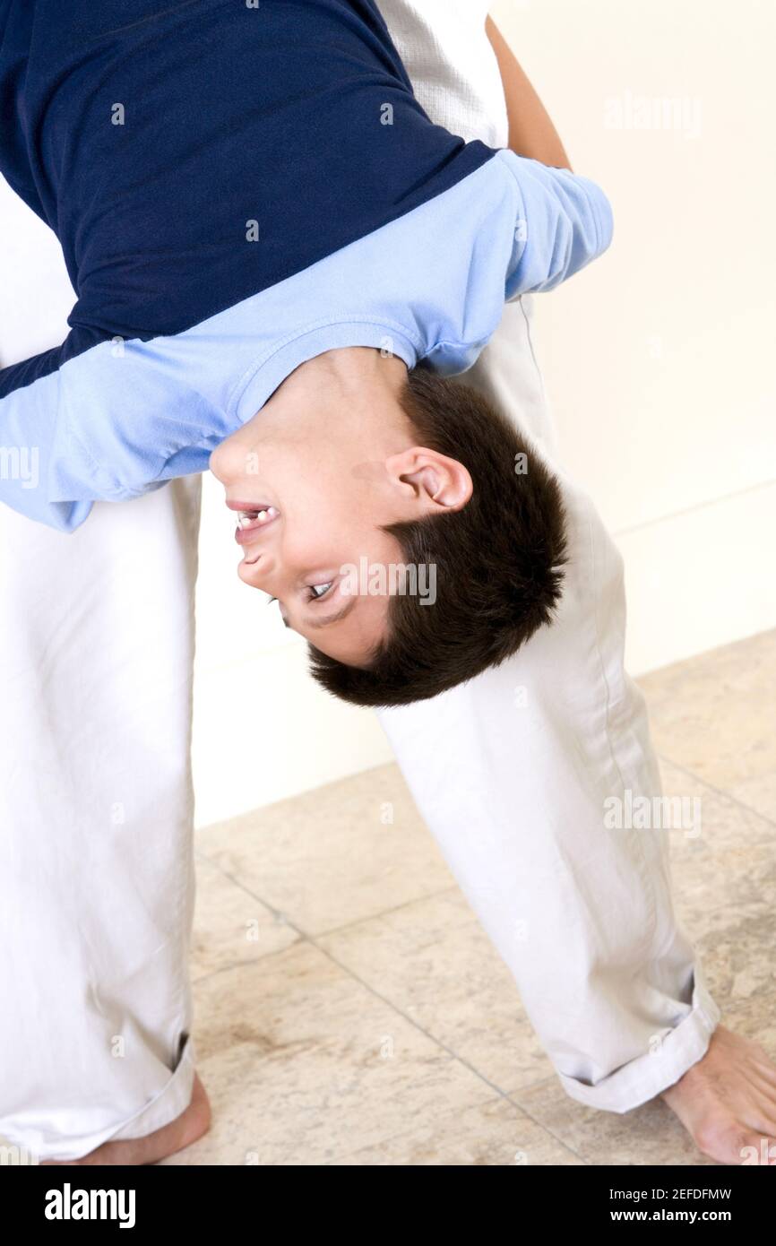 Low section view of a man holding a boy upside down Stock Photo - Alamy