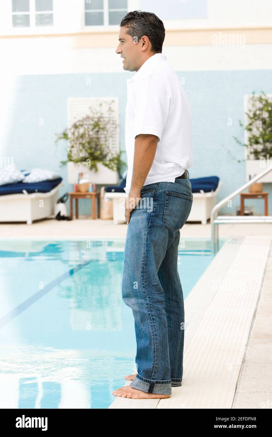 Side profile of a mid adult man standing at the poolside Stock Photo ...