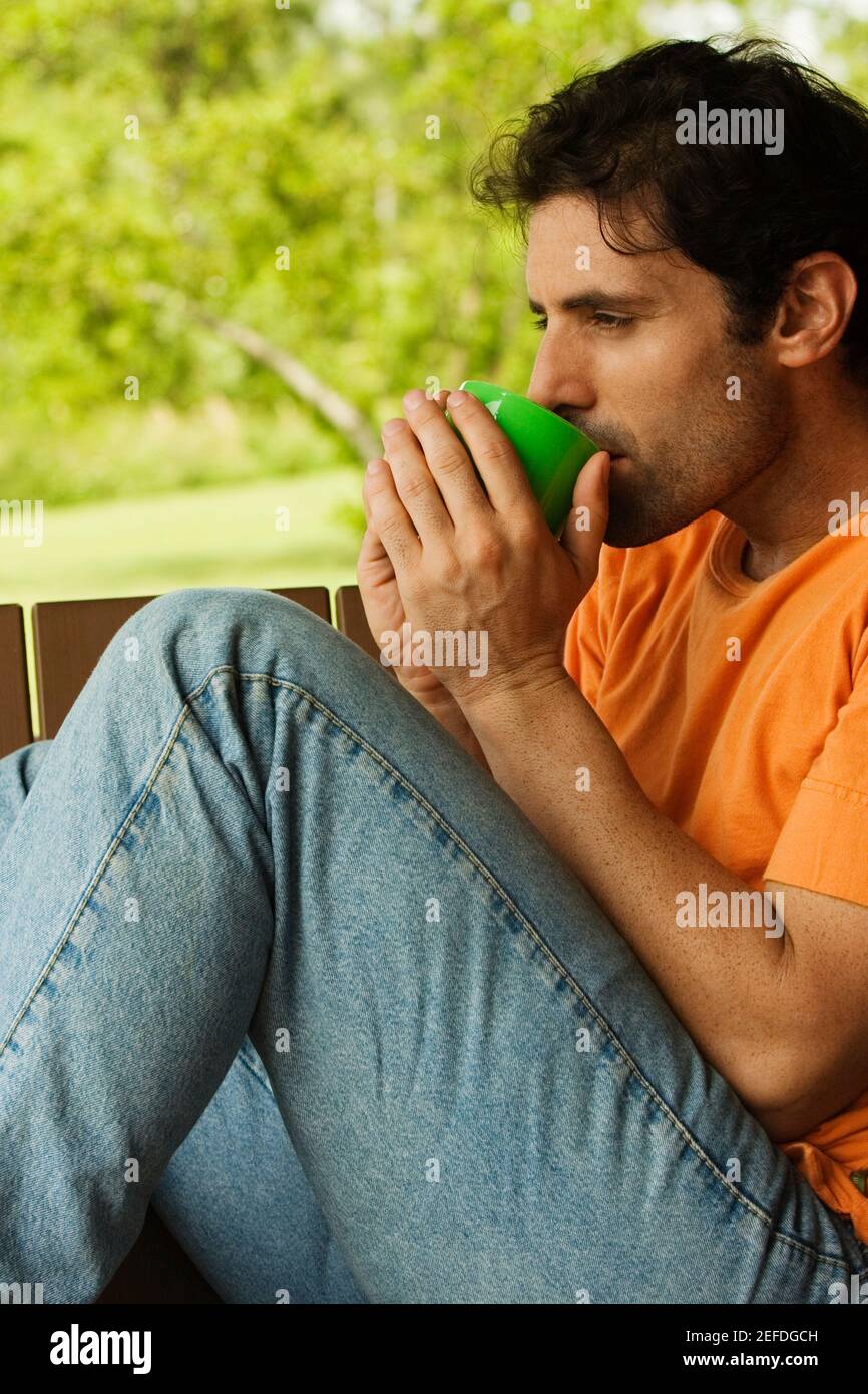 Side profile of a mid adult man drinking from a mug Stock Photo - Alamy